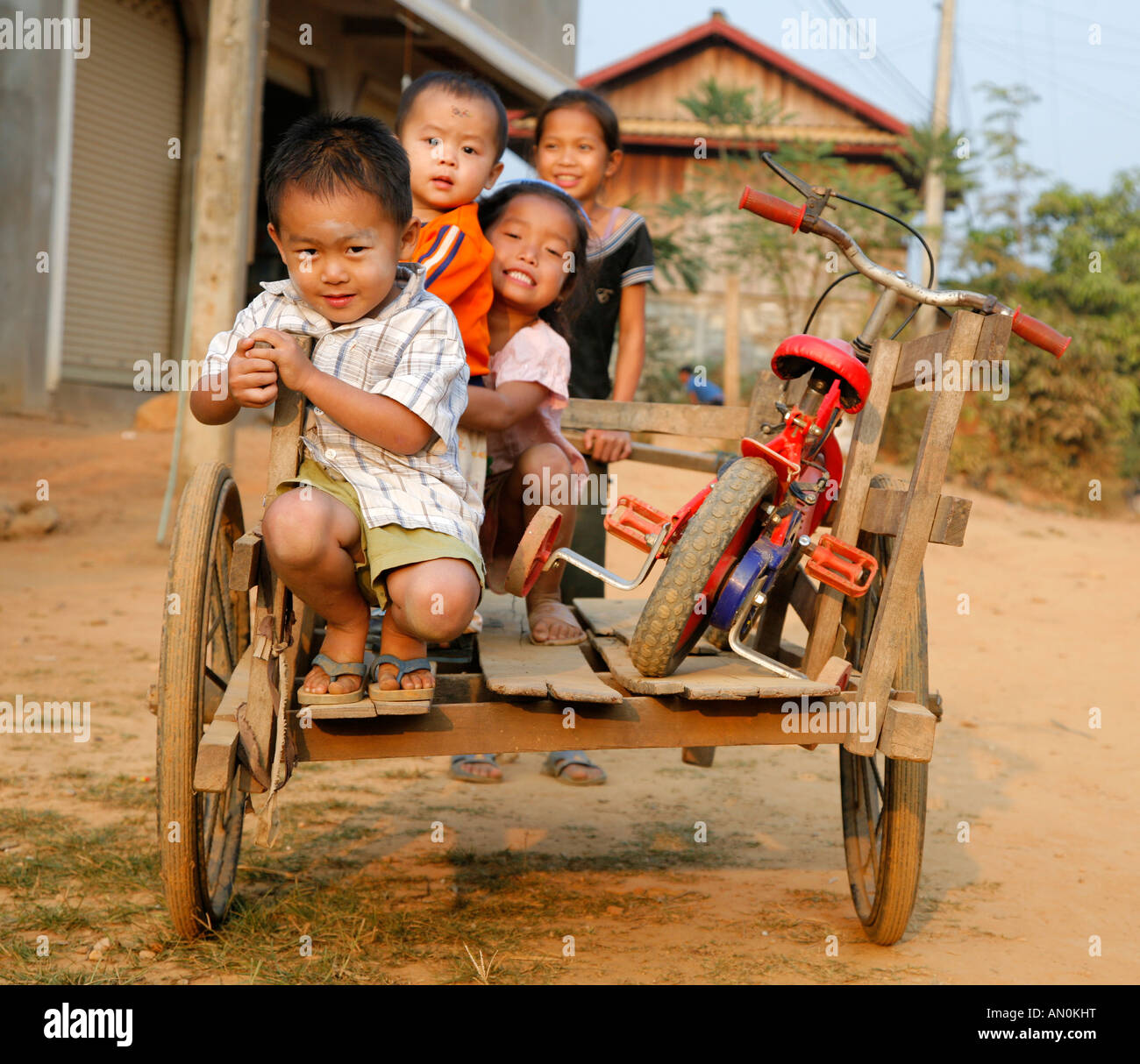 Kids in a rural village in Northern Laos playing with a hand cart Stock ...