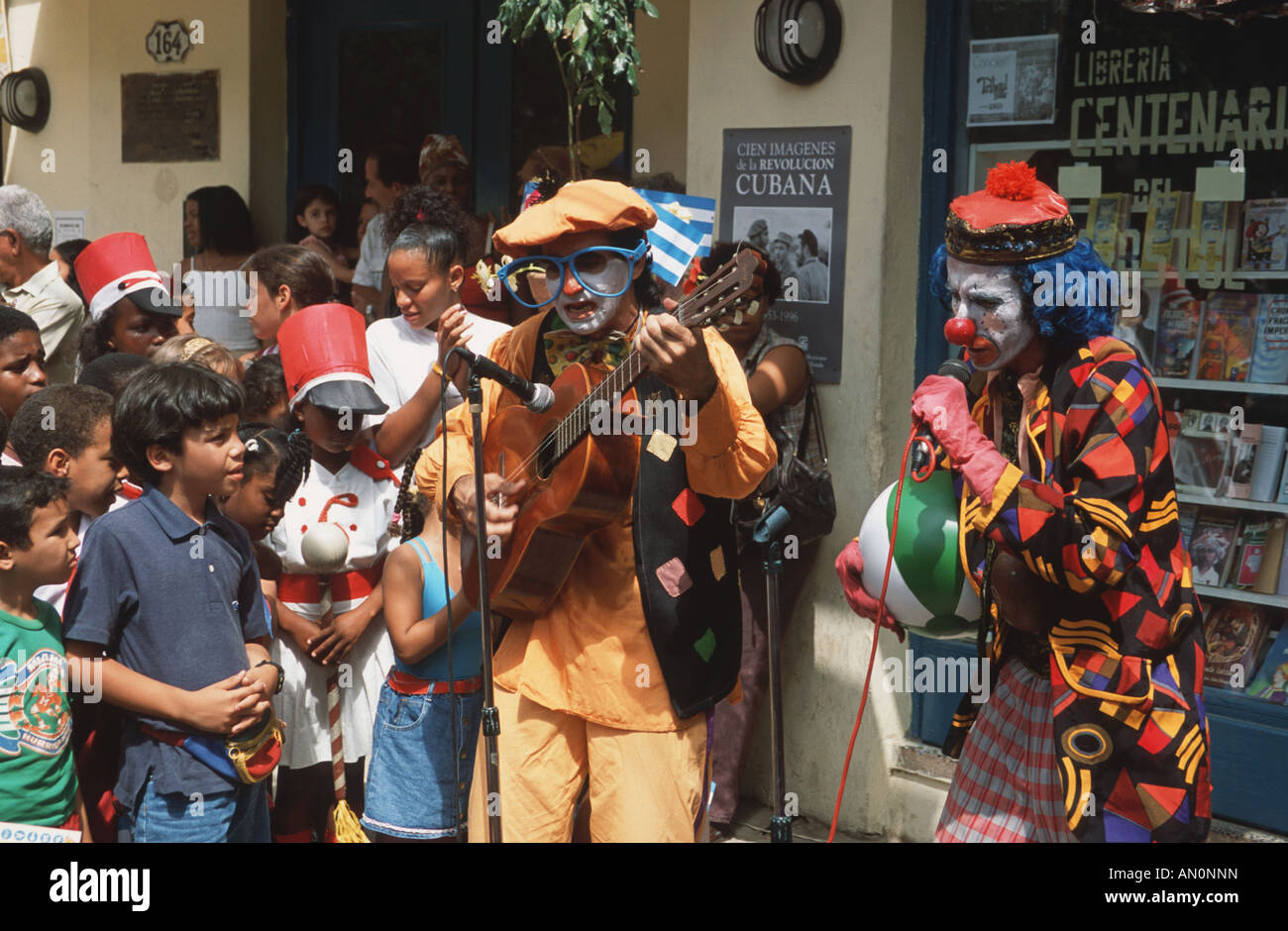 Clowns singing and playing guitars to entertain children on the streets ...