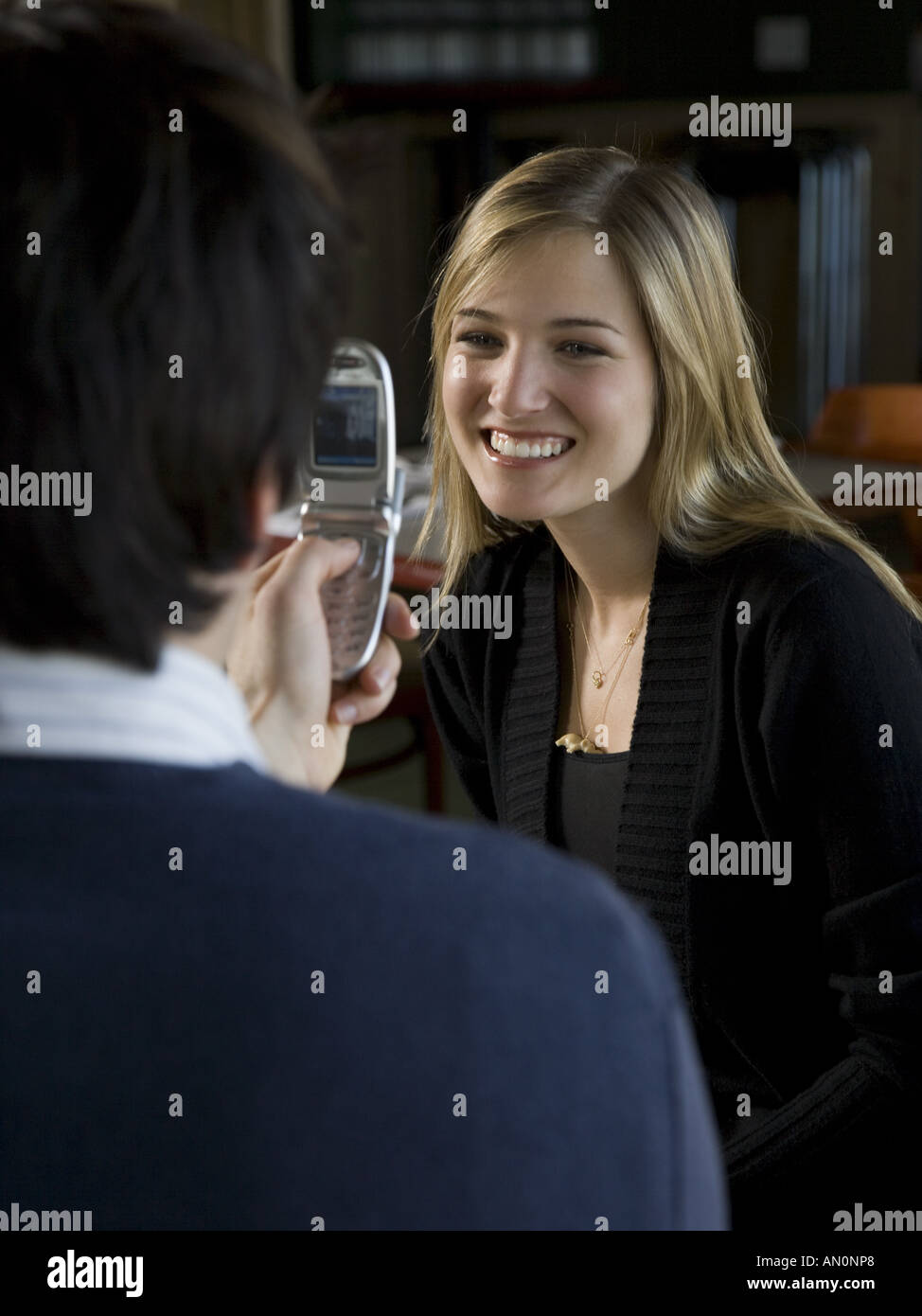 Rear view of a young man taking a photograph of a young woman Stock ...