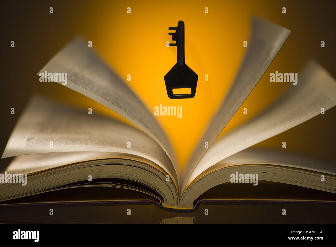 Key hovering above open book Stock Photo - Alamy
