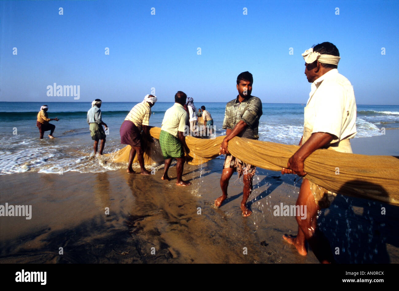 fisherman pulling out their fishing net from the sea Stock Photo - Alamy