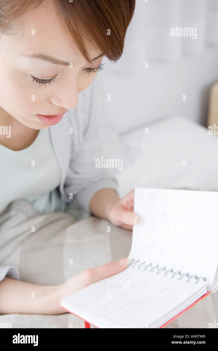Japanese woman checking a notebook Stock Photo - Alamy
