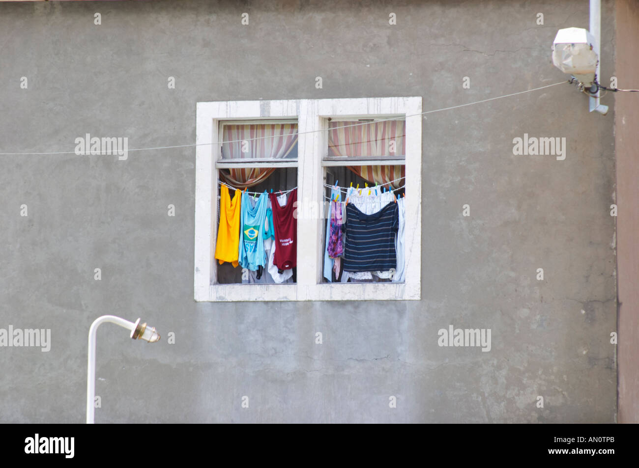 A window with clothes lines washing hanging to dry. White window frames ...