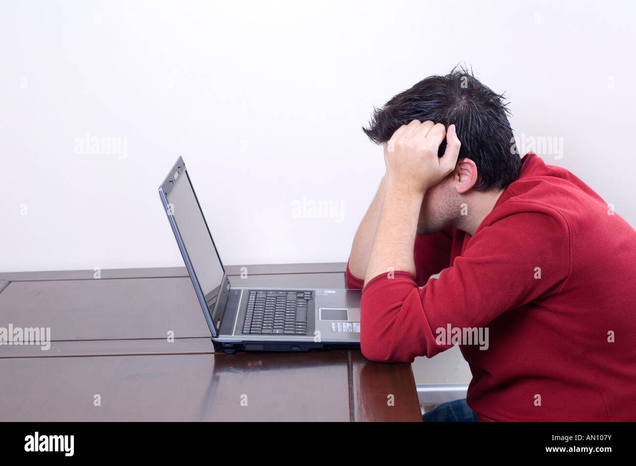 Frustrated man looking at laptop screen Stock Photo - Alamy