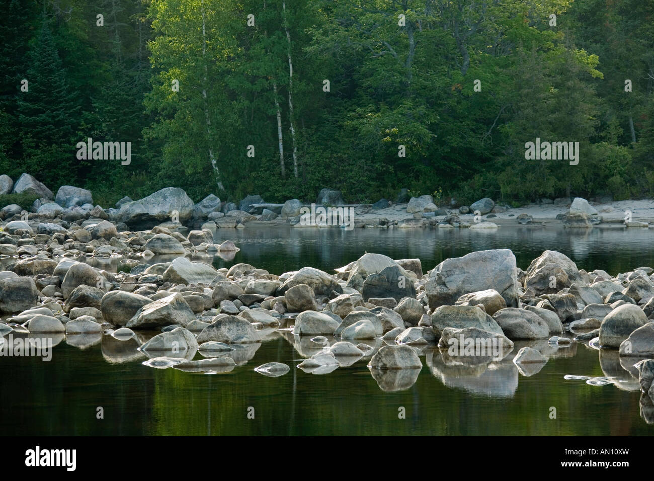 Lake with rocks and woods Stock Photo - Alamy