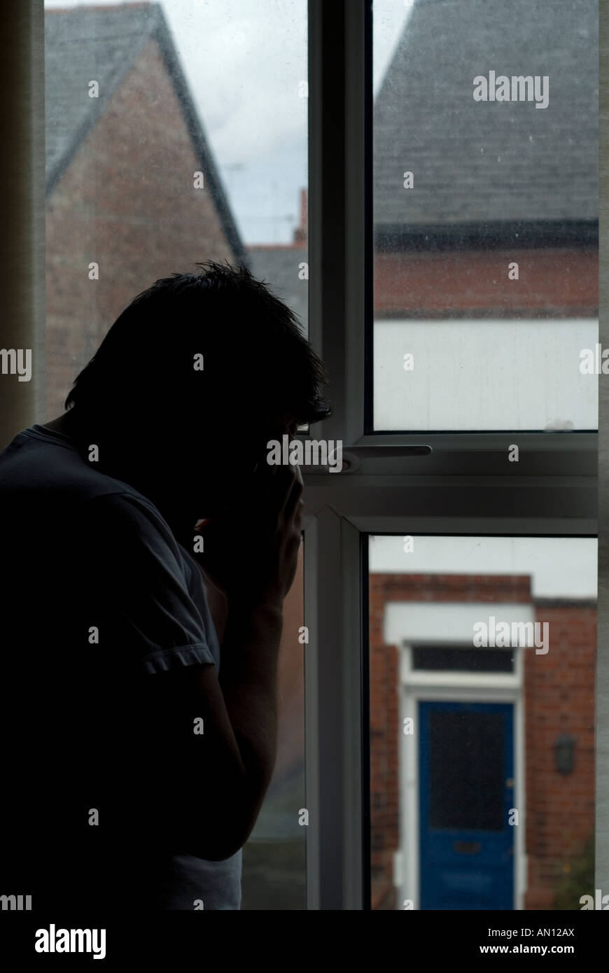 Depressed man by the window Stock Photo - Alamy