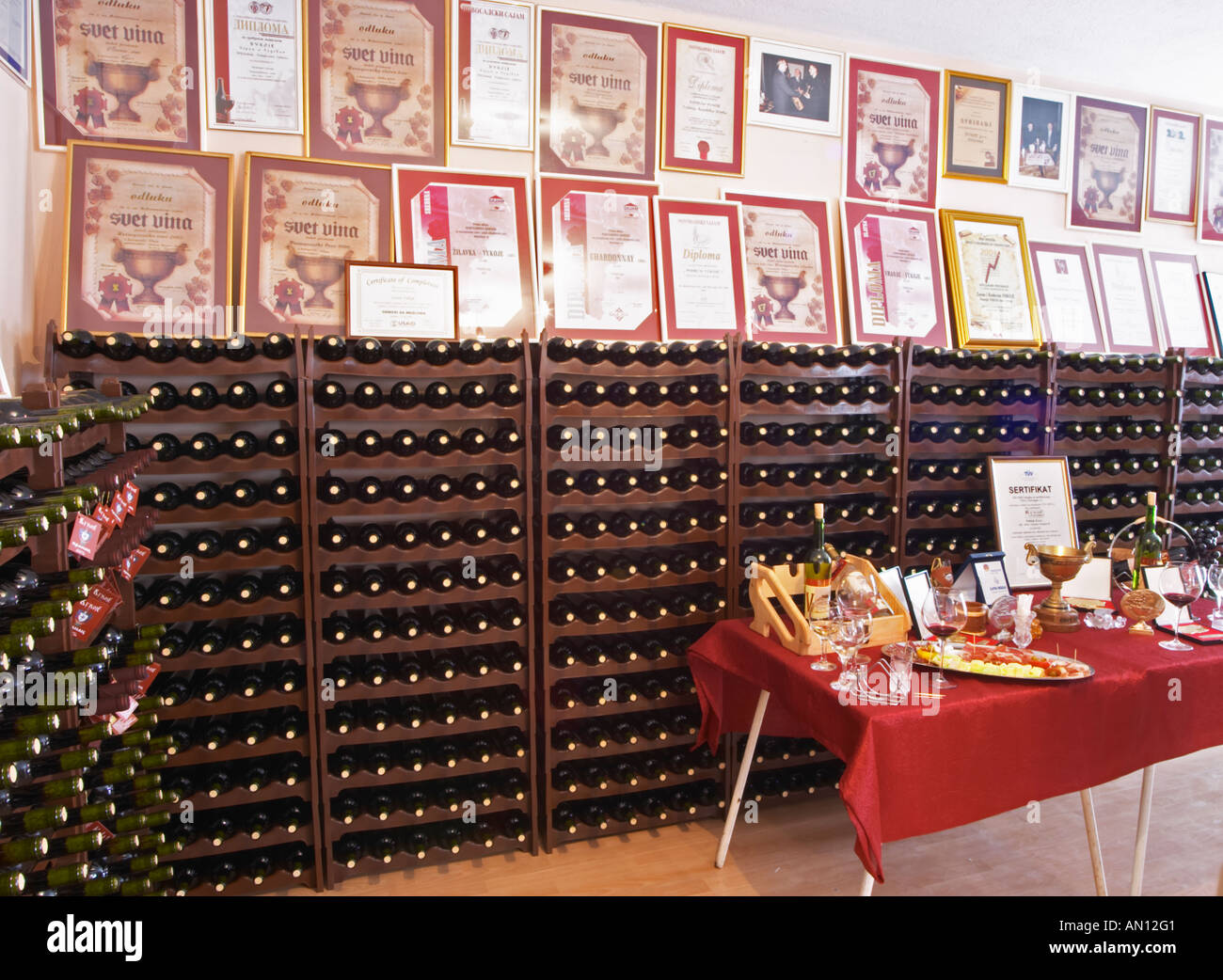 Plenty of bottles stacked on shelves and many diplomas from wine ...
