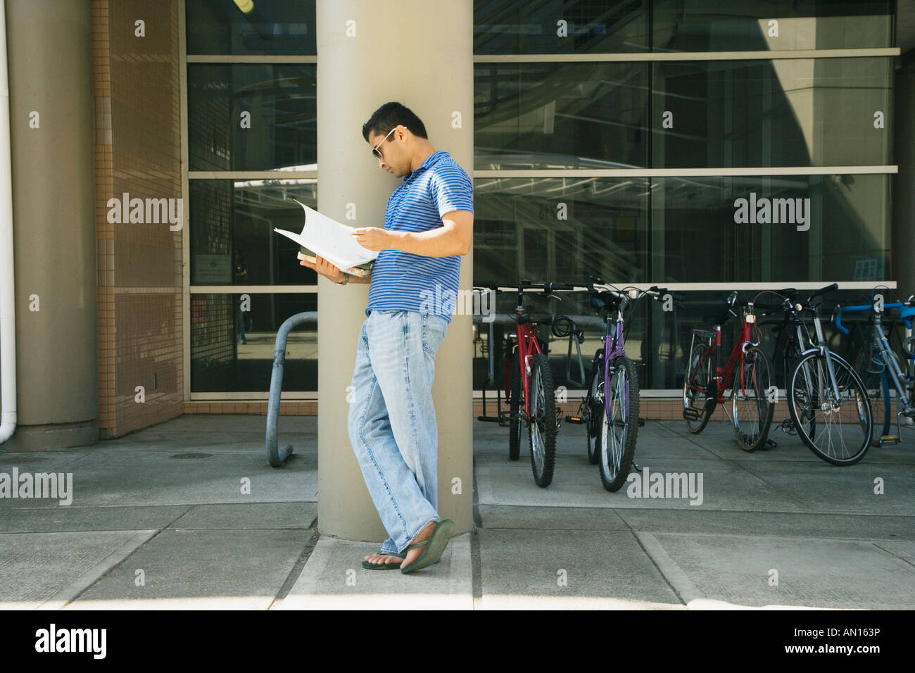 Asian man reading paperwork outdoors Stock Photo - Alamy