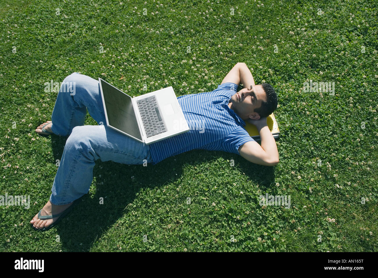 Asian male college student laying on grass Stock Photo - Alamy