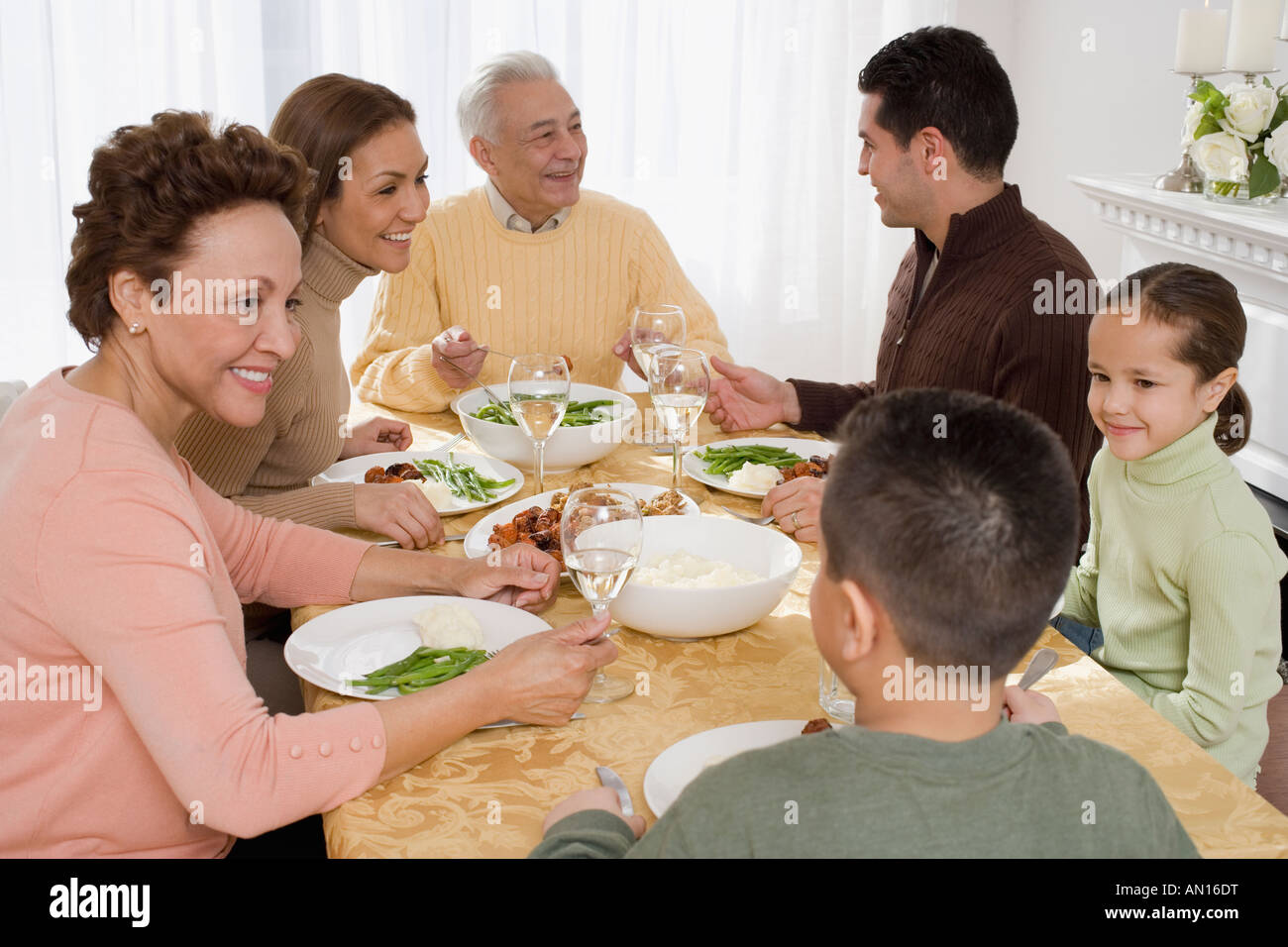 Multi-generational Hispanic family eating at Thanksgiving table Stock ...