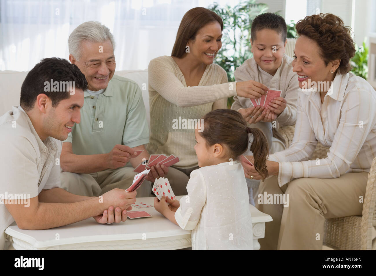 Multi-generational Hispanic family playing cards Stock Photo - Alamy