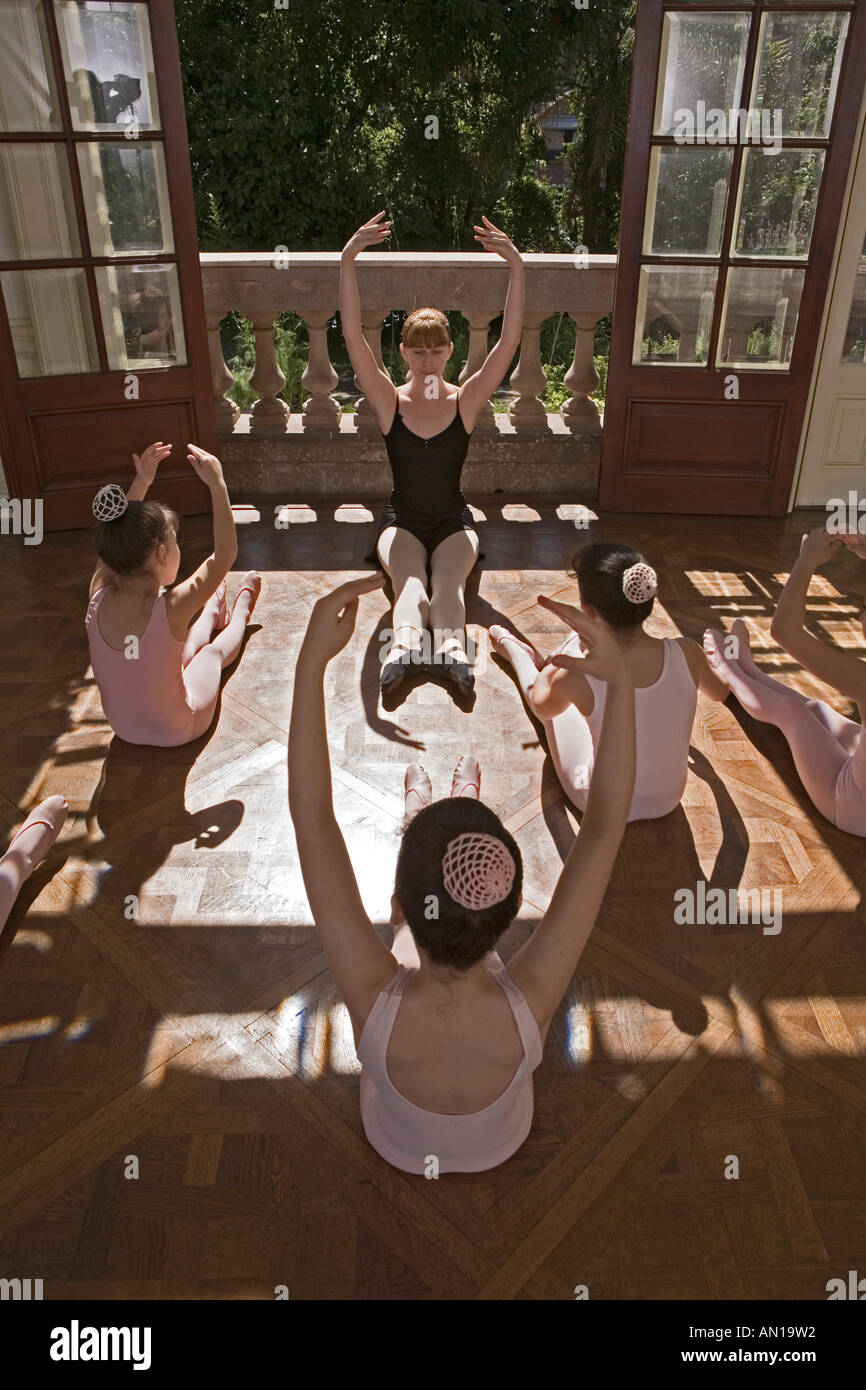 Ballet teacher and young girls stretching in ballet lesson Stock Photo ...