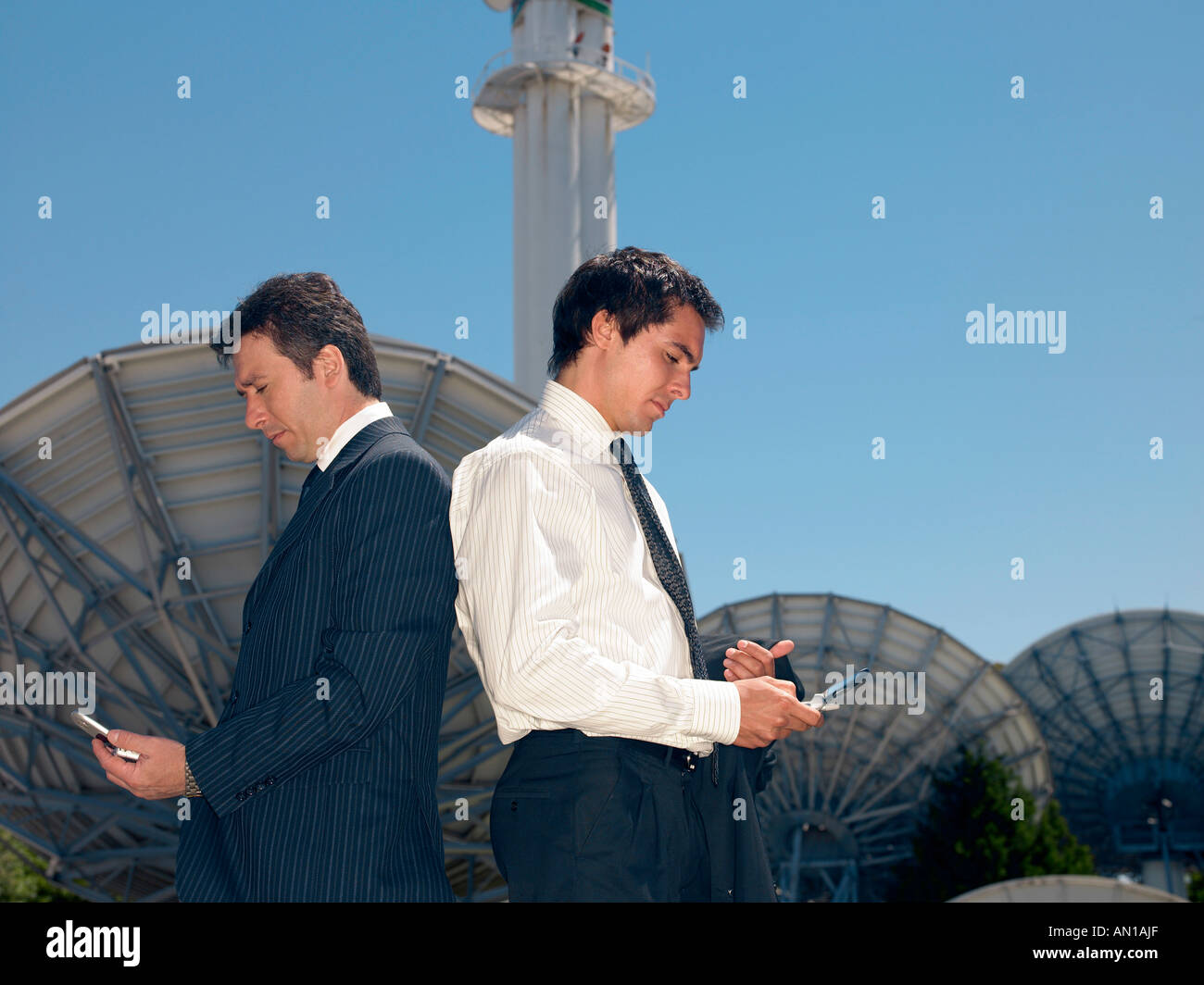 Two businessmen standing back to back Stock Photo - Alamy