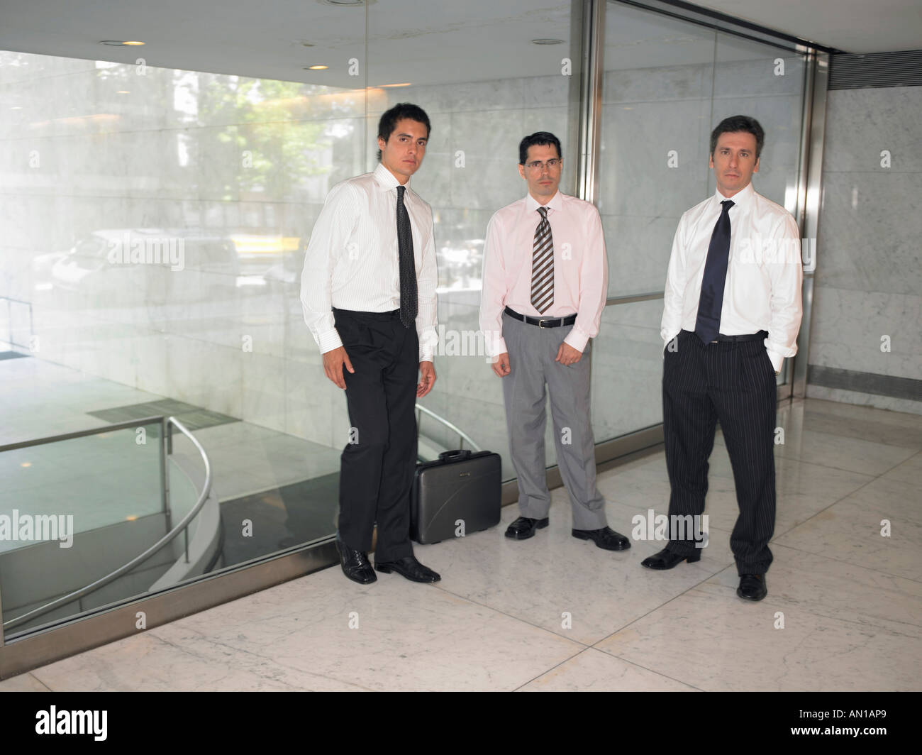 Three businessmen standing staring straight at the camera Stock Photo ...