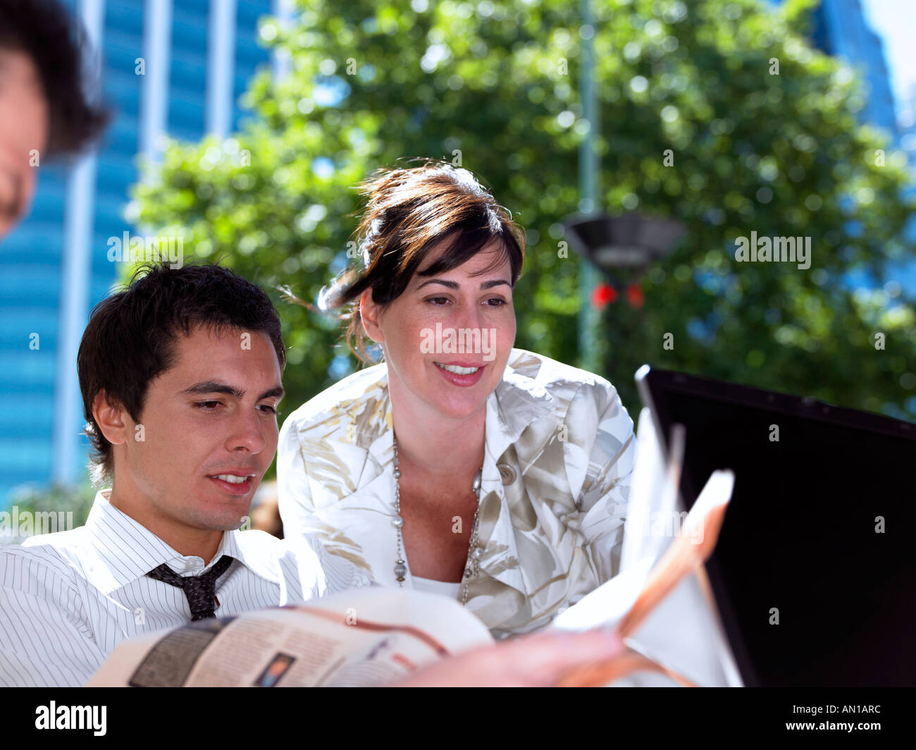 Two people looking at a laptop Stock Photo - Alamy