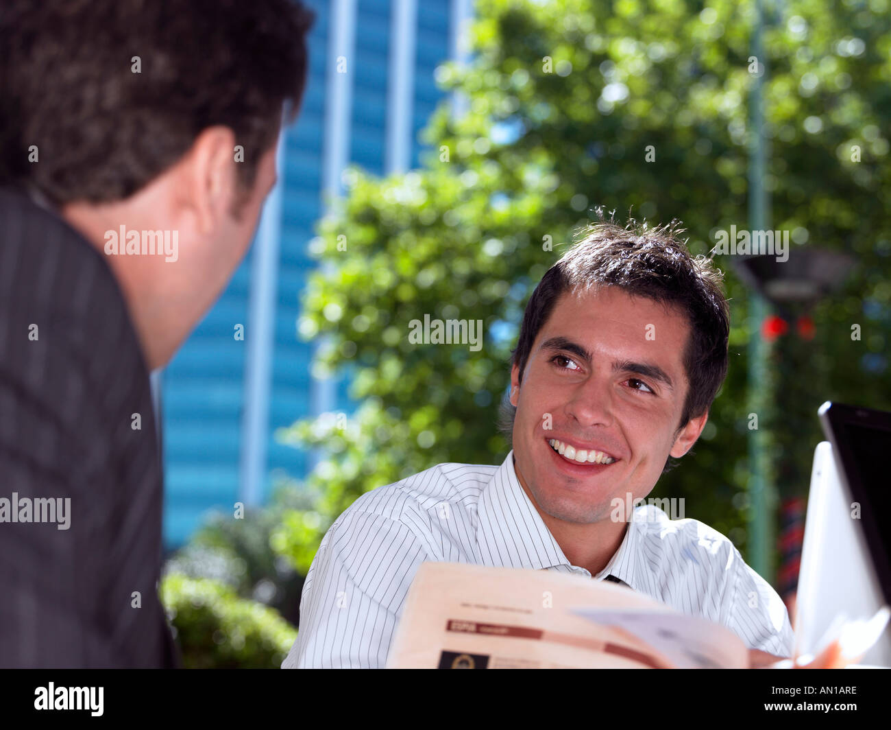 Two men smiling and talking Stock Photo - Alamy