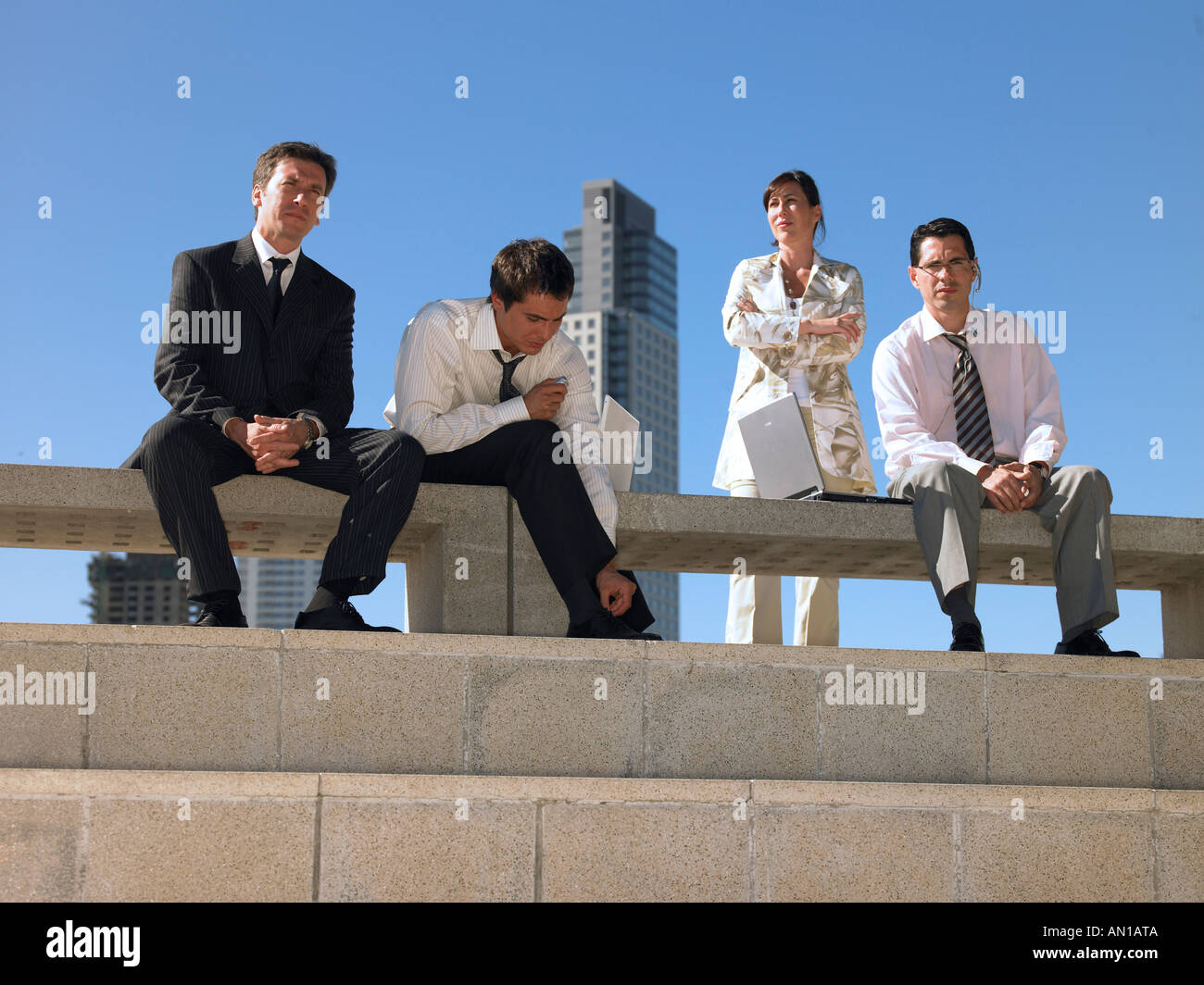 Four people in front of a tall building Stock Photo - Alamy