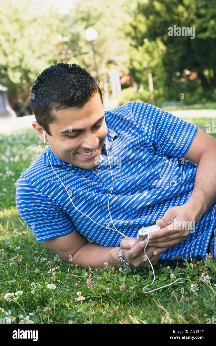 Indian man listening to mp3 player Stock Photo - Alamy