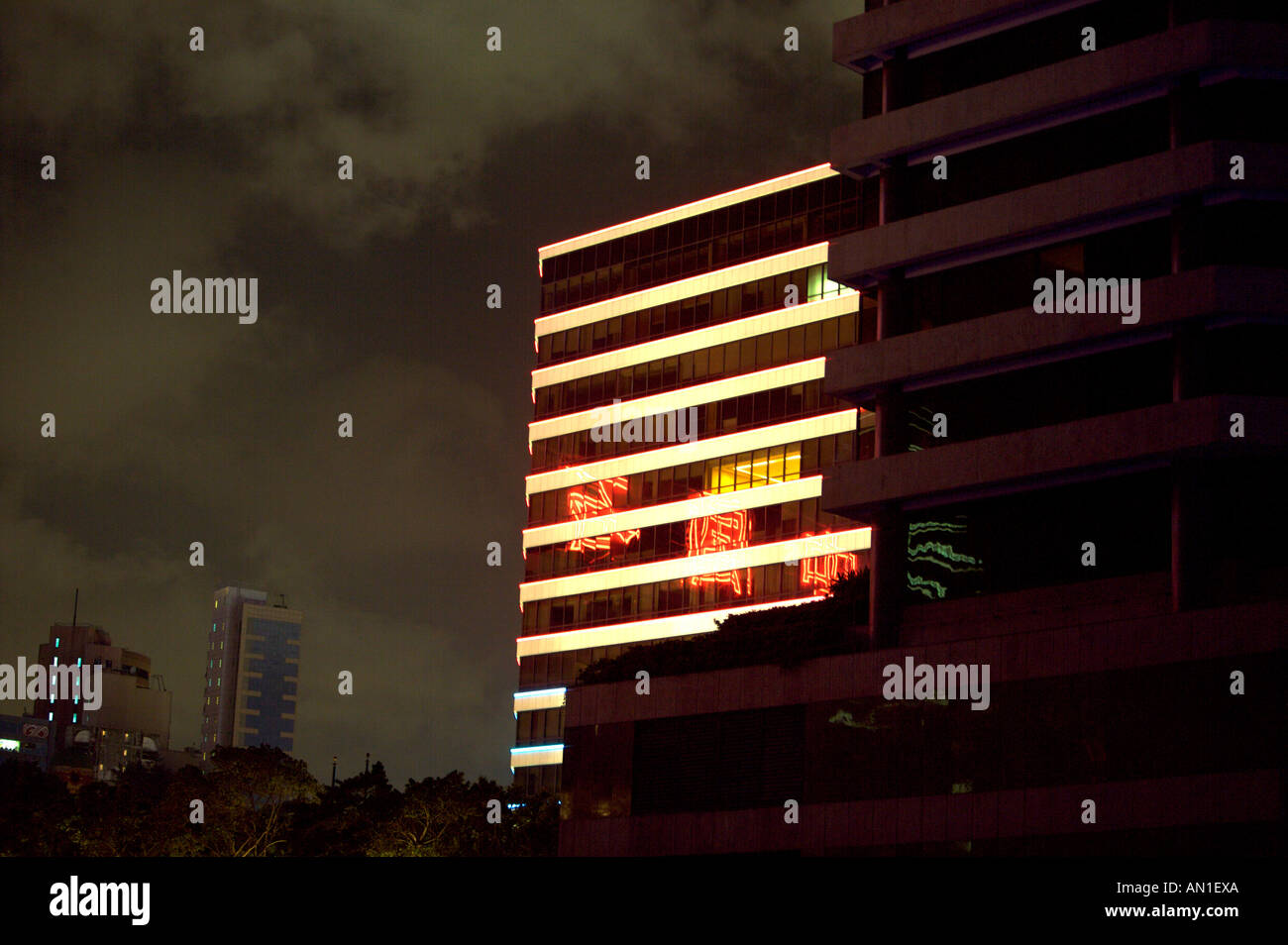 A neon-light building, with reflections of a sign in Chinese characters ...