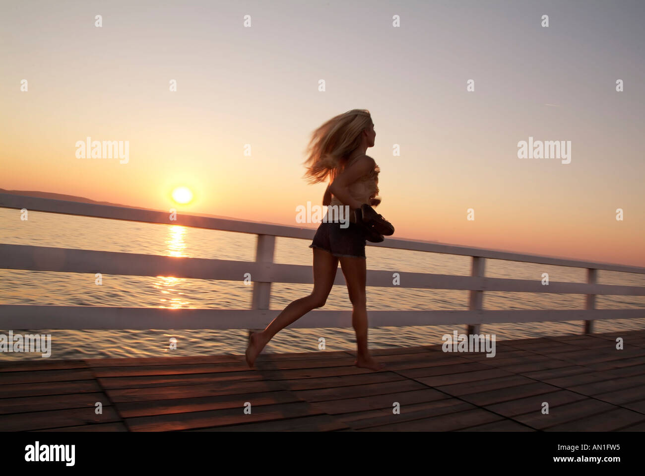young woman relaxing at beach, sunset, backlight, chillout Stock Photo ...