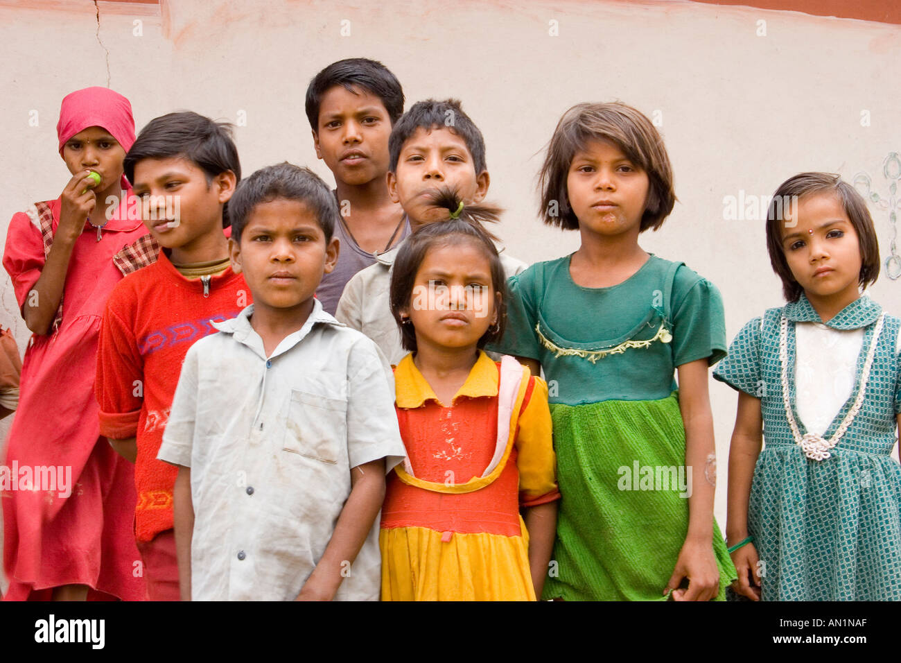 Indian children, standing side by side in front of a wall, India ...