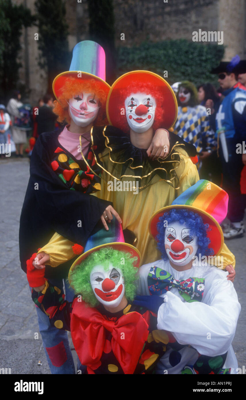 Group of clowns standing in street wearing colourful costumes at ...