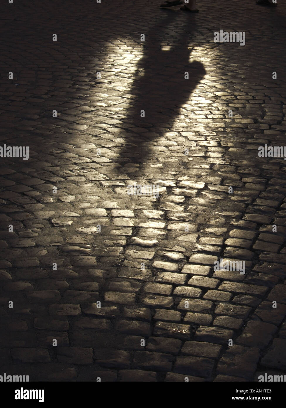 shadow of person on cobbled street at sunset Stock Photo - Alamy