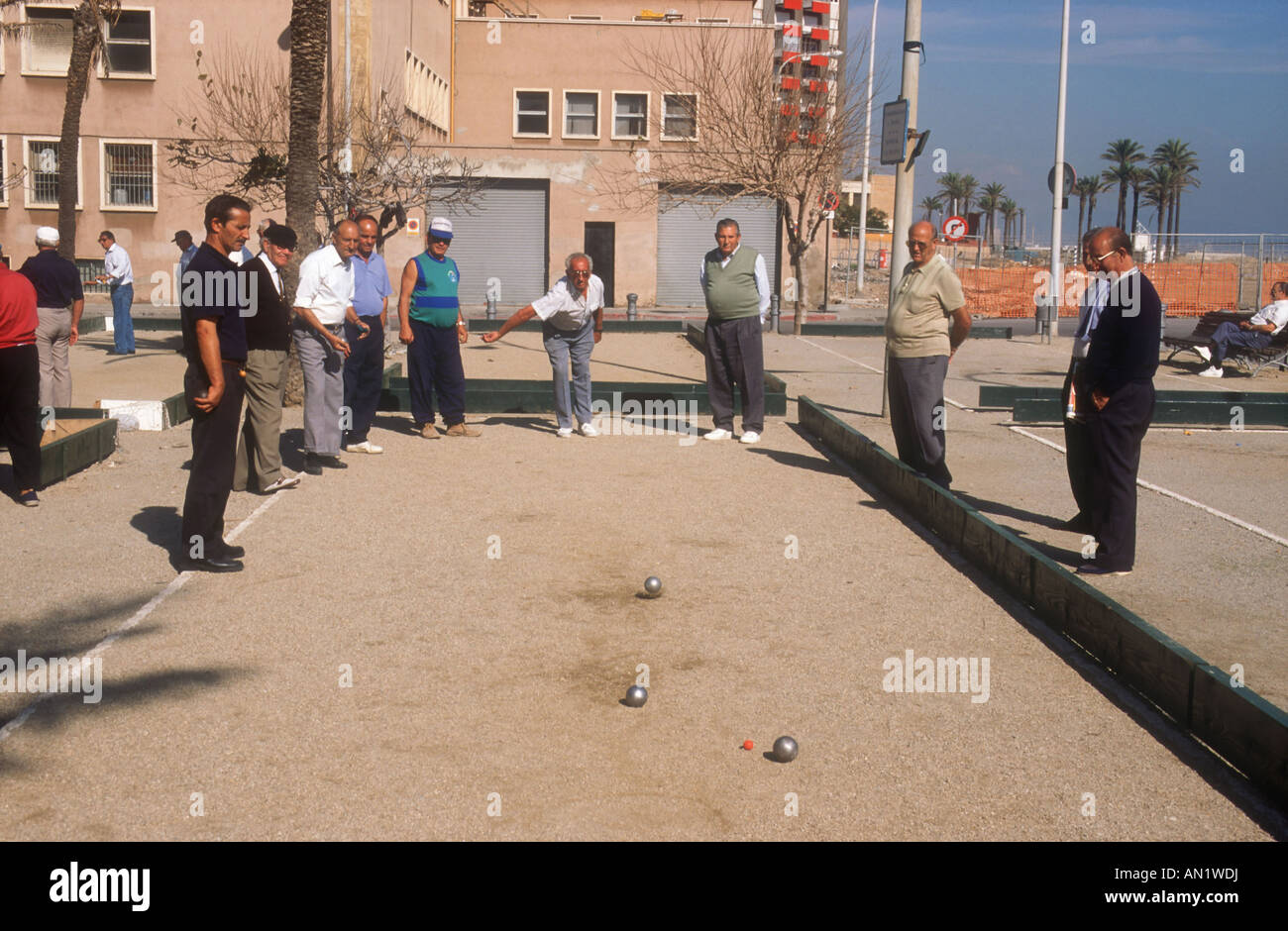 Group of men playing game of boules in street. Spain Stock Photo - Alamy