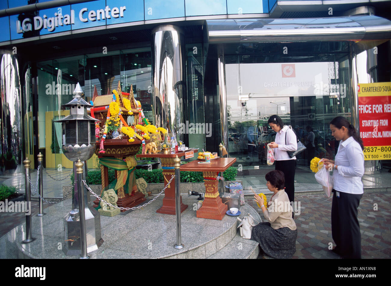 Thailand, Bangkok, Female Office Workers Preying at Small Shrine in ...