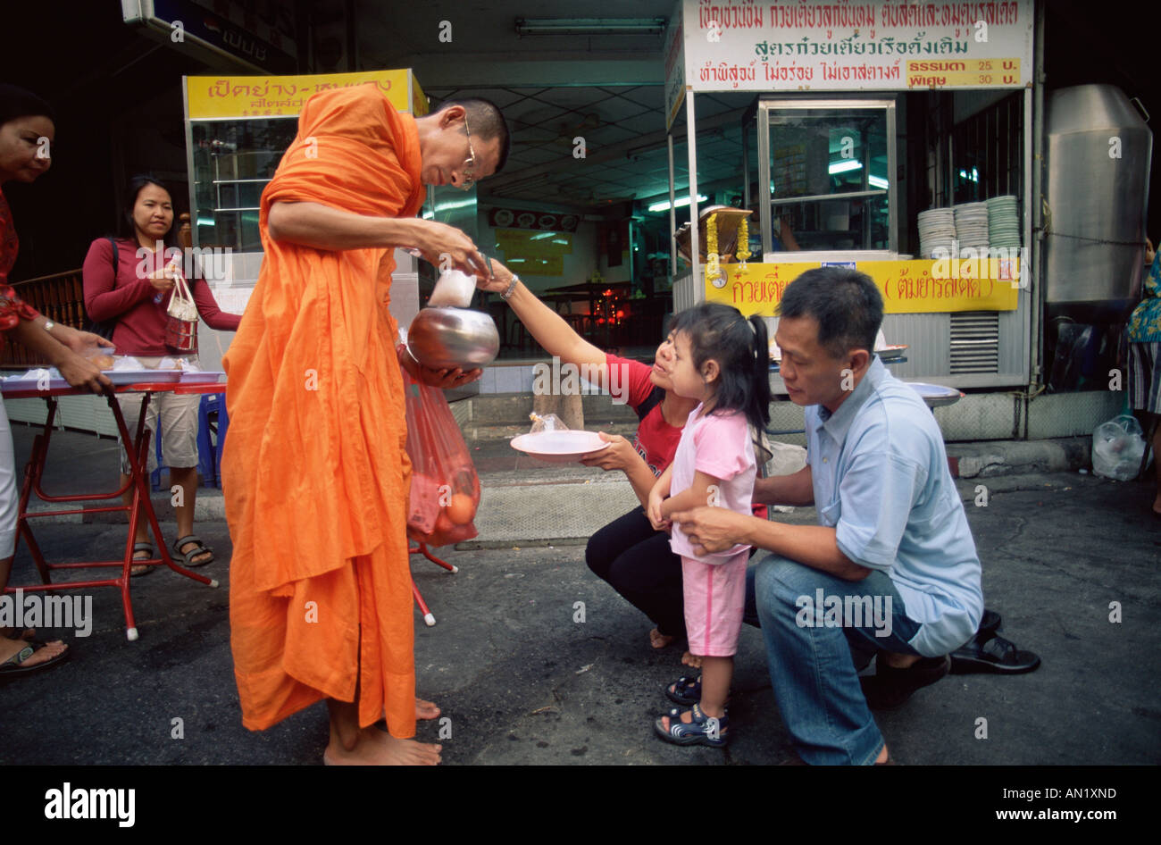 Thailand, Bangkok, Family Giving Alms to Monk Stock Photo - Alamy