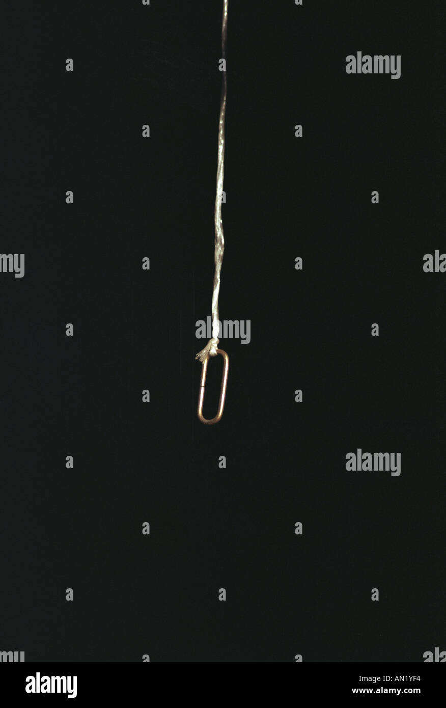 one paperclip tied to piece of string Stock Photo - Alamy