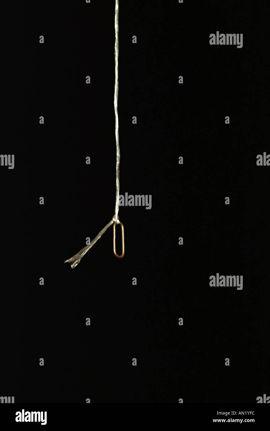 one paperclip tied to piece of string Stock Photo - Alamy