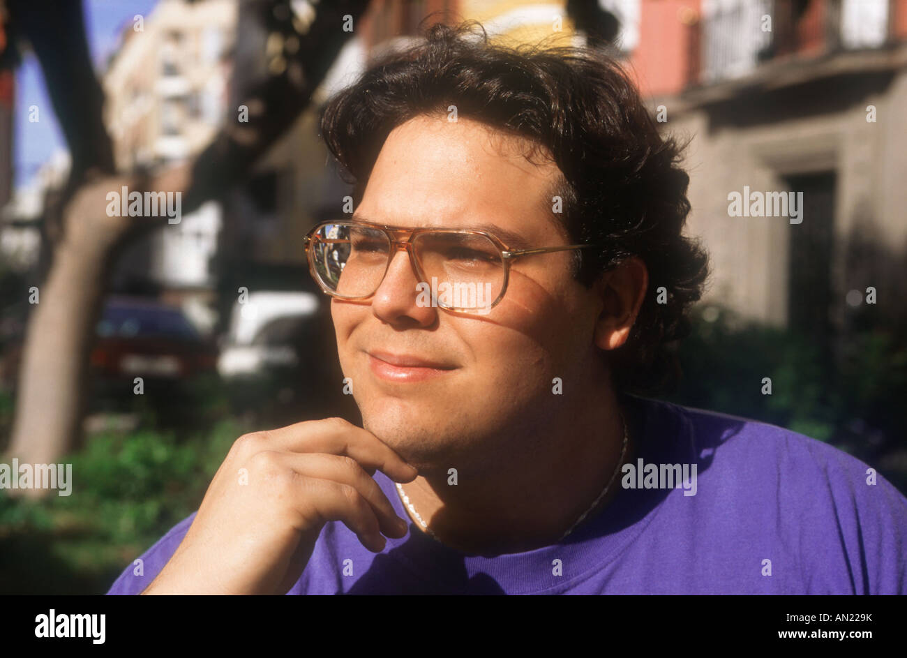 Portrait of teenage boy sitting outside looking thoughtful. Spain Stock ...
