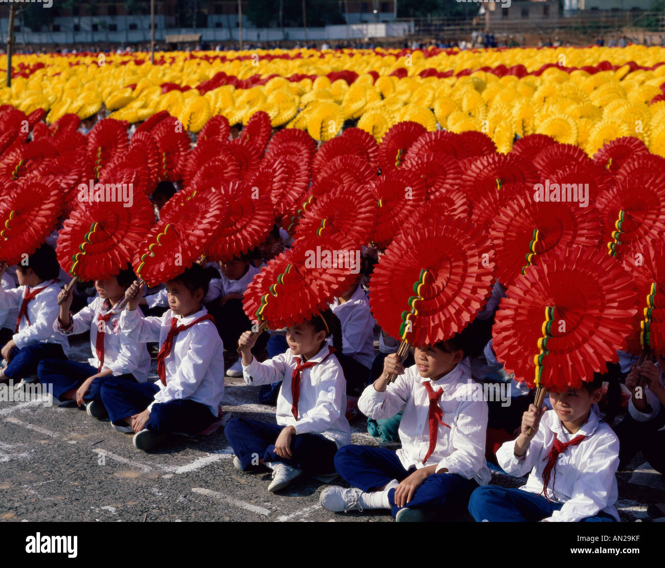 Group of school children holding red and yellow fans hi-res stock ...