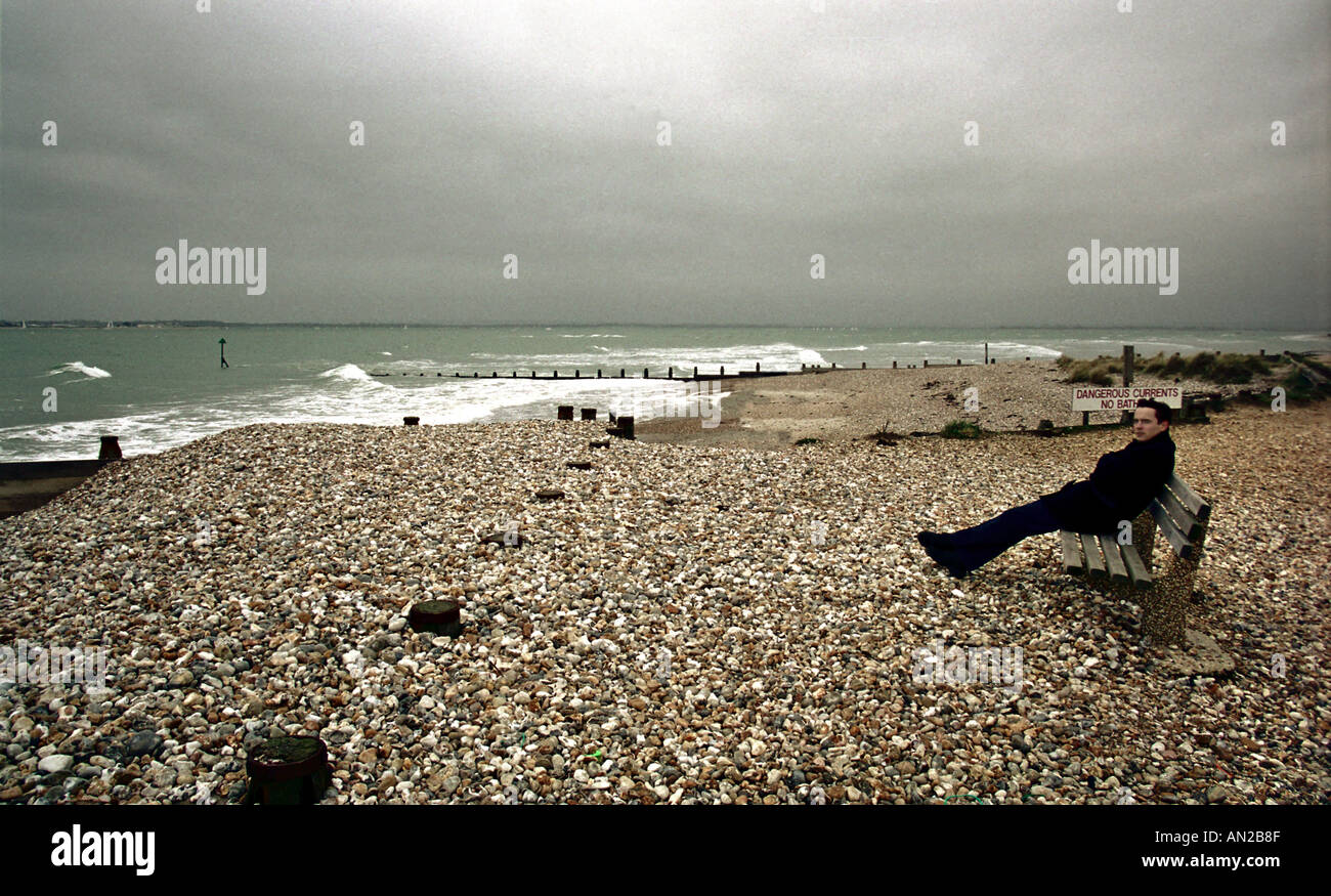 Man sitting on bench at Beach recline, England seashore Stock Photo - Alamy