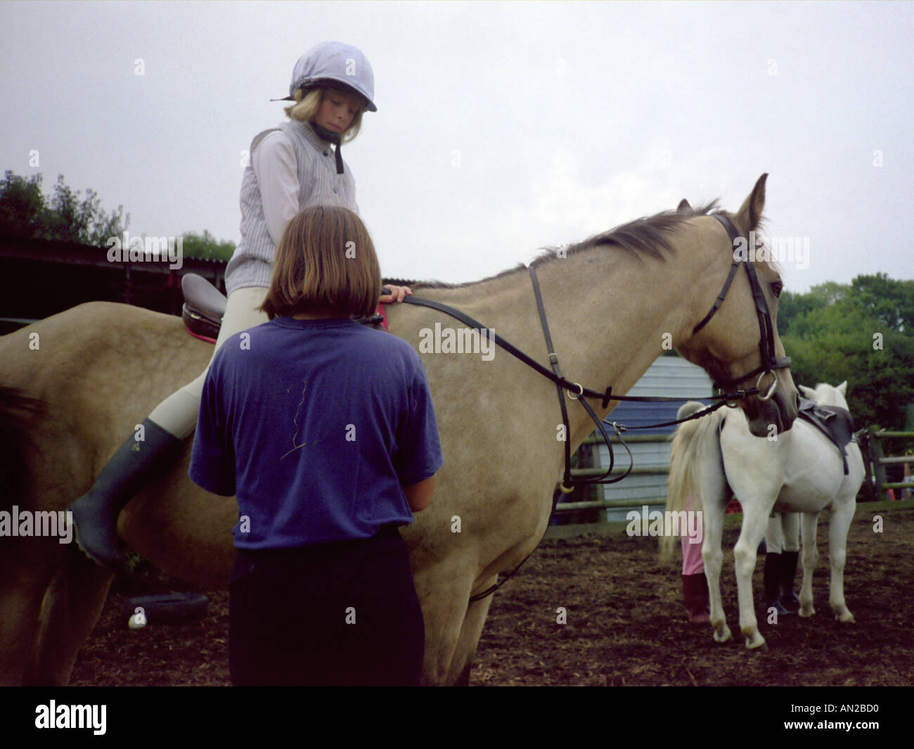girl on horse with helper Stock Photo - Alamy