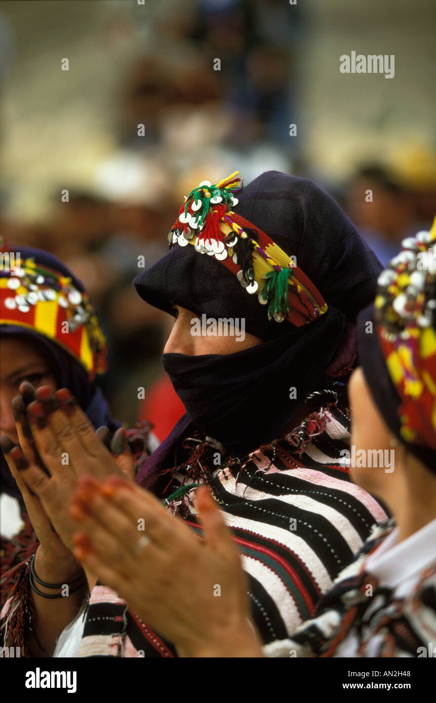 Veiled Berber women dance and clap their hands during a mock marriage ...
