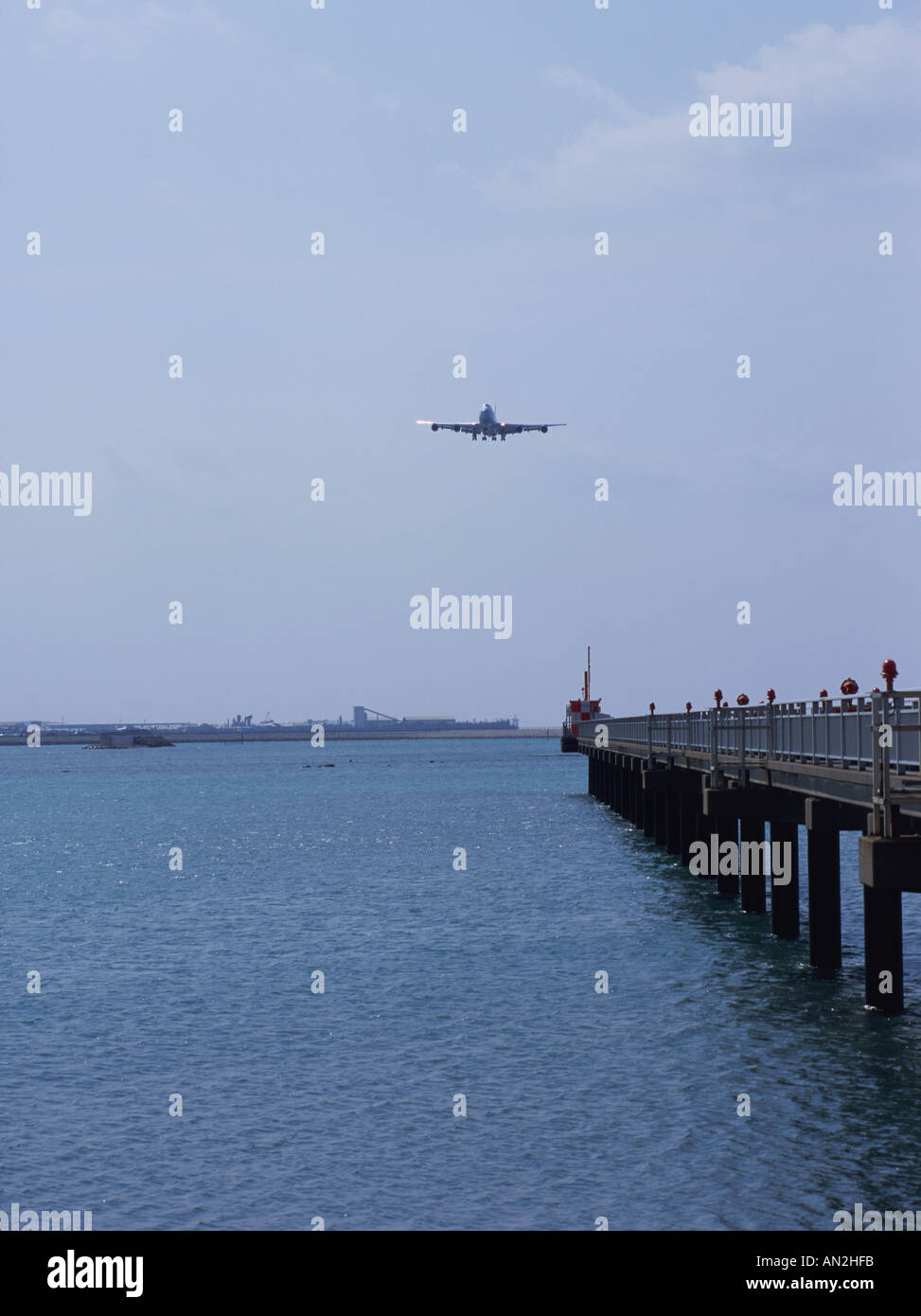 Passenger airplane flying over pier Stock Photo - Alamy