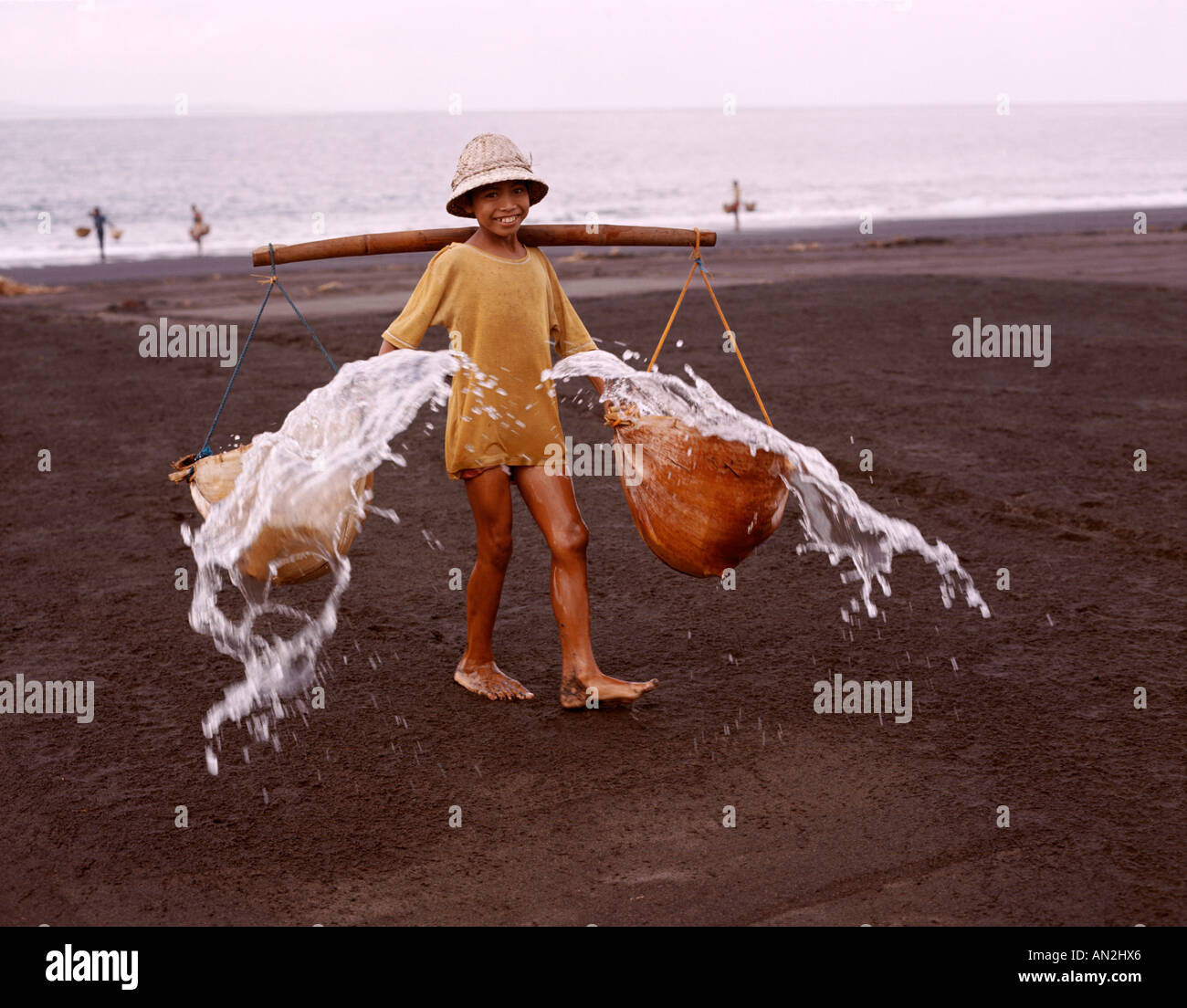 Salt Maker / Young Boy Throwing Seawater onto Sand to Make Salt, Bali ...