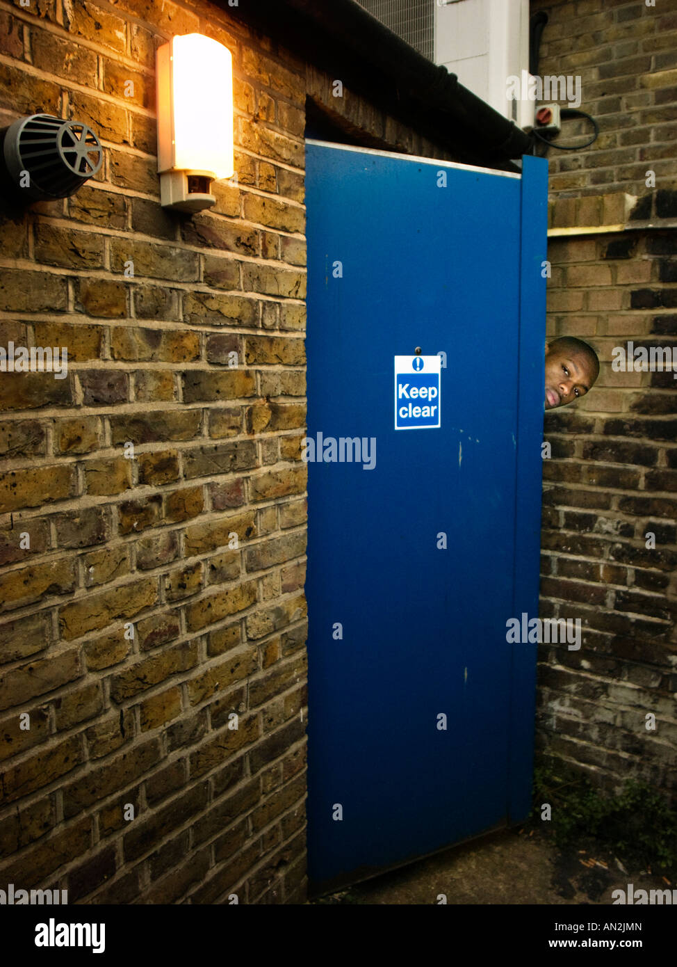 man behind metal security door Stock Photo - Alamy
