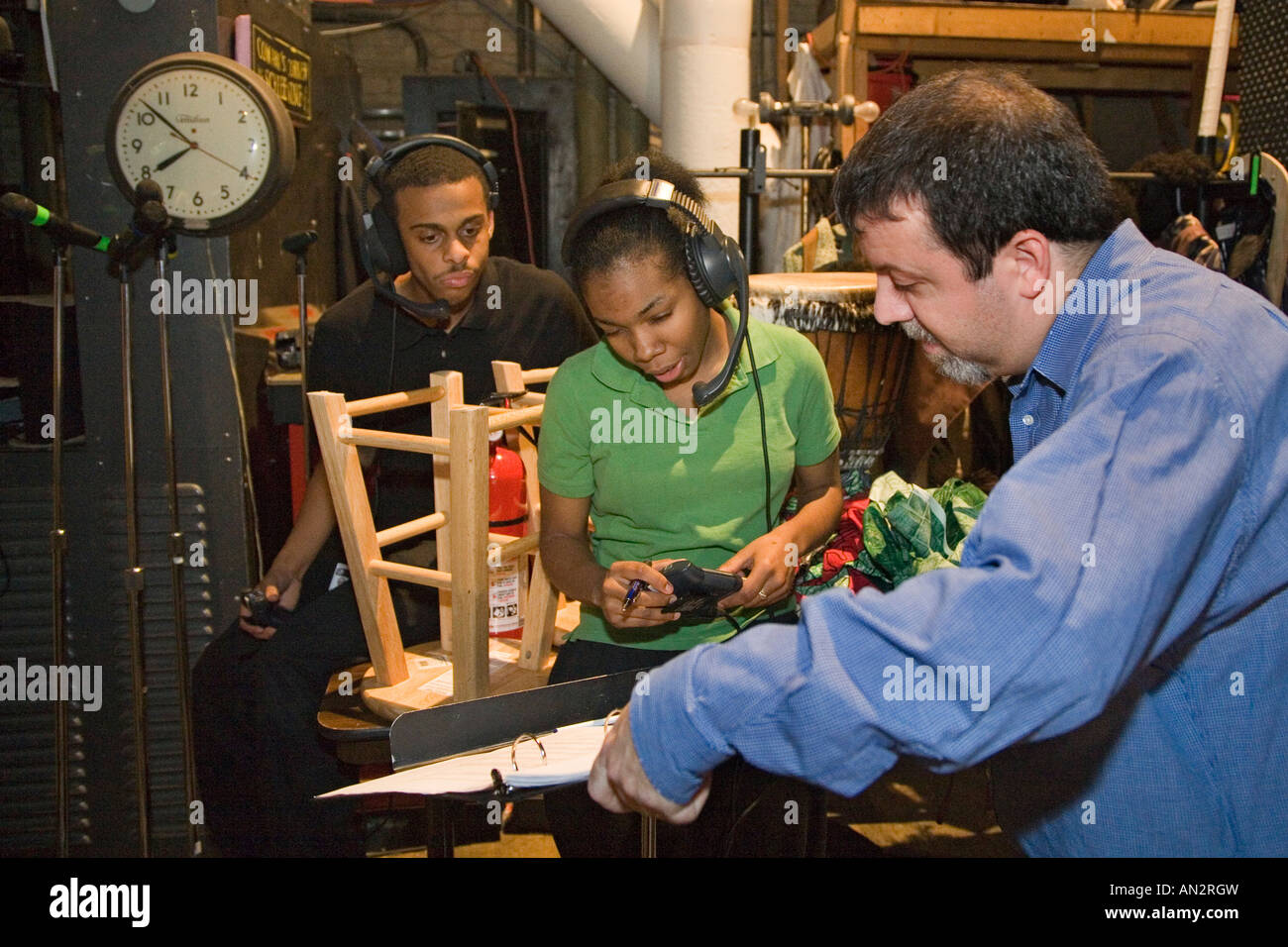 Director of youth theater talks to backstage crew before rehearsal ...