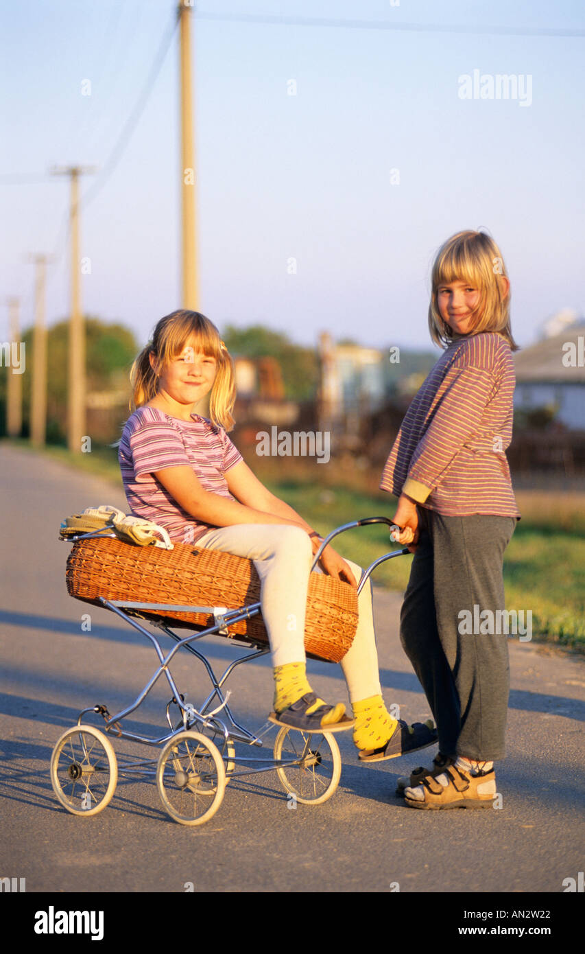 TWO GIRLS PLAYING WITH BABY CARRIAGE Stock Photo - Alamy