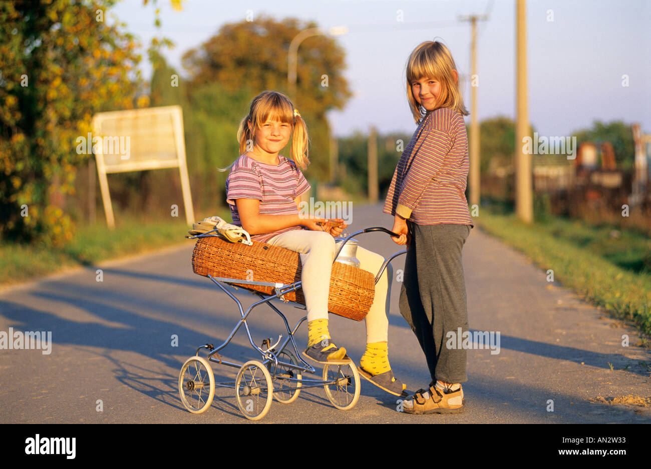 TWO GIRLS PLAYING WITH BABY CARRIAGE Stock Photo - Alamy