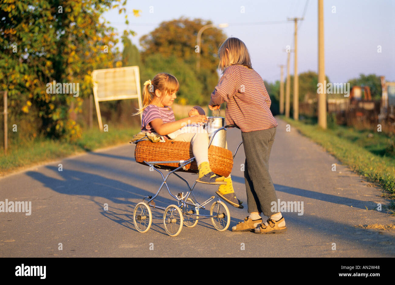 TWO GIRLS PLAYING WITH BABY CARRIAGE Stock Photo - Alamy