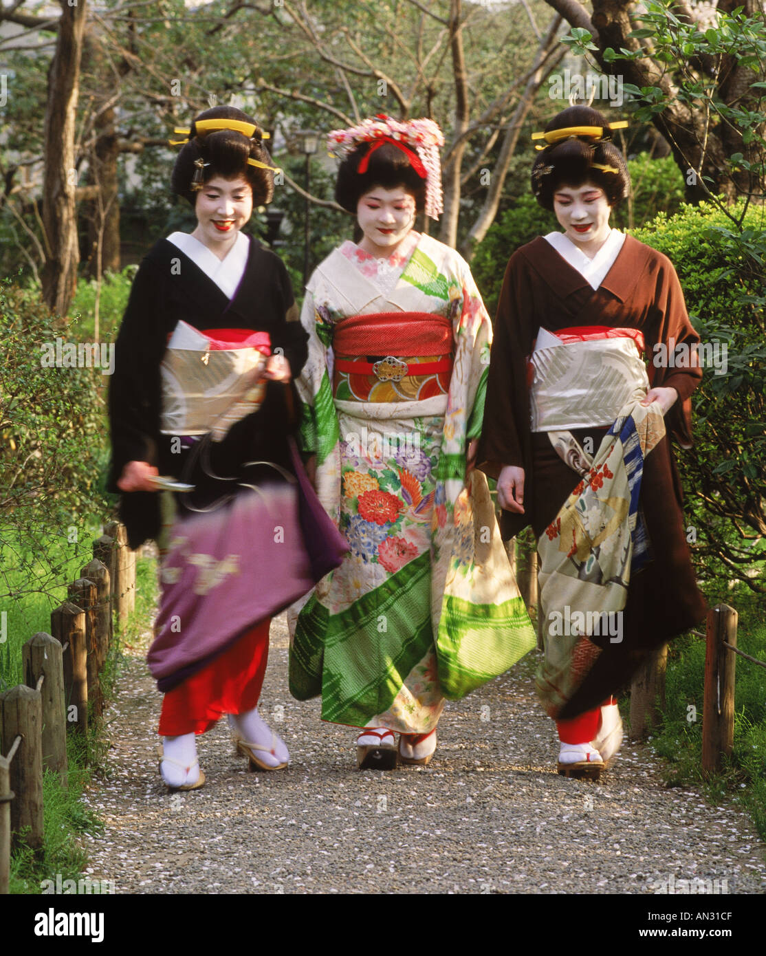 Geisha women in colorful kimonos on pathway in Tokyo park Stock Photo ...