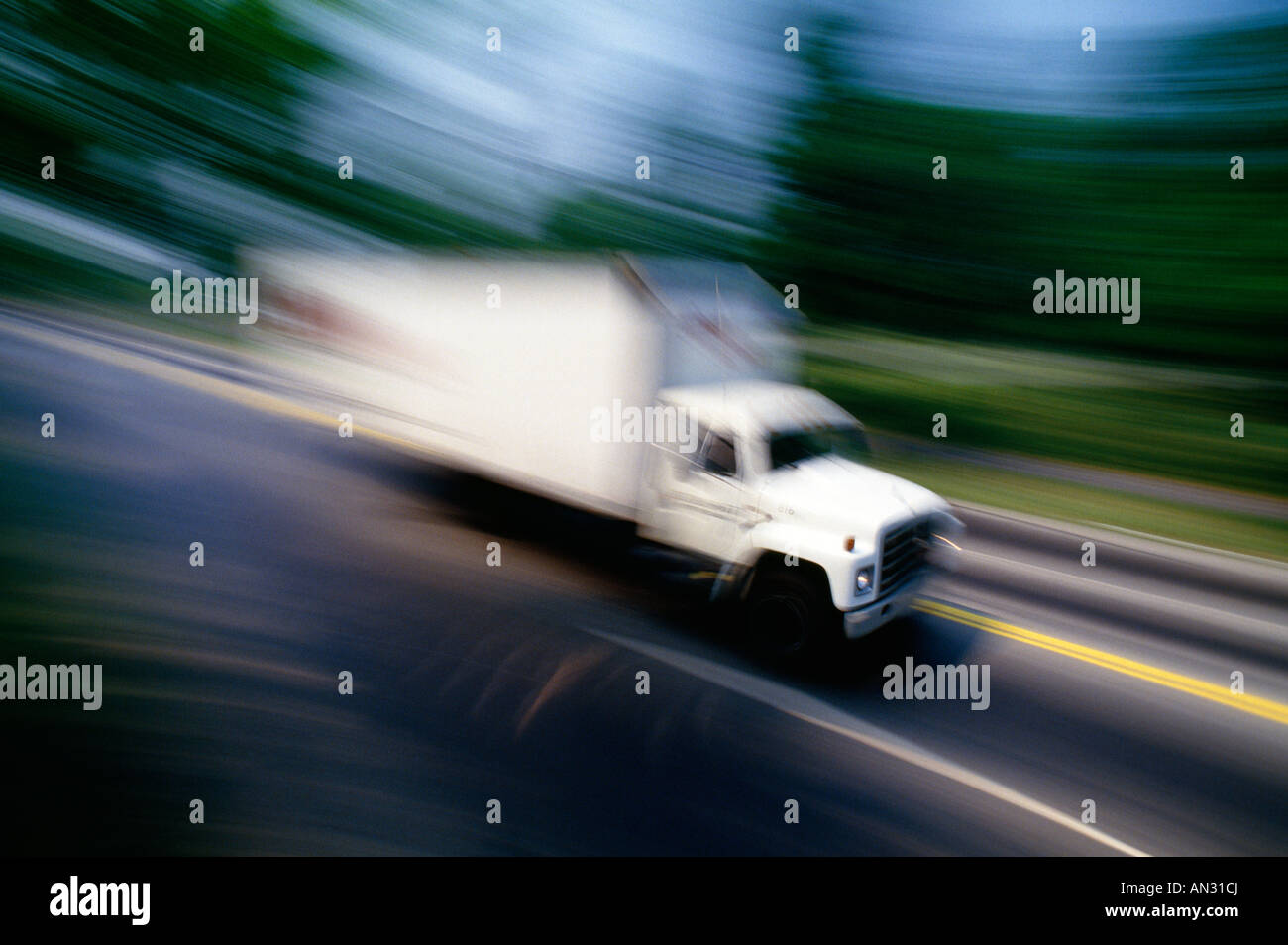 Fast Moving White Truck Speeds Along Two Lane Road Stock Photo - Alamy