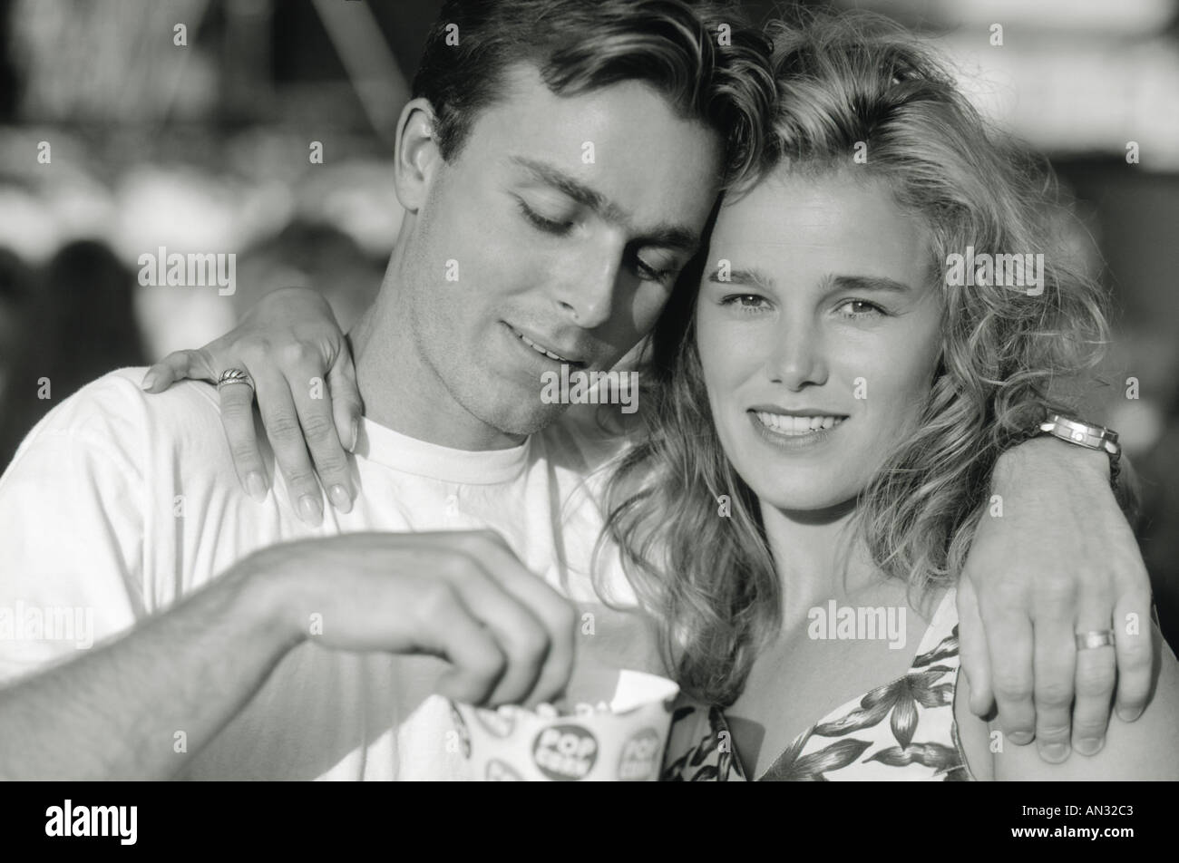 Black and white image of romantic young couple eating popcorn at ...