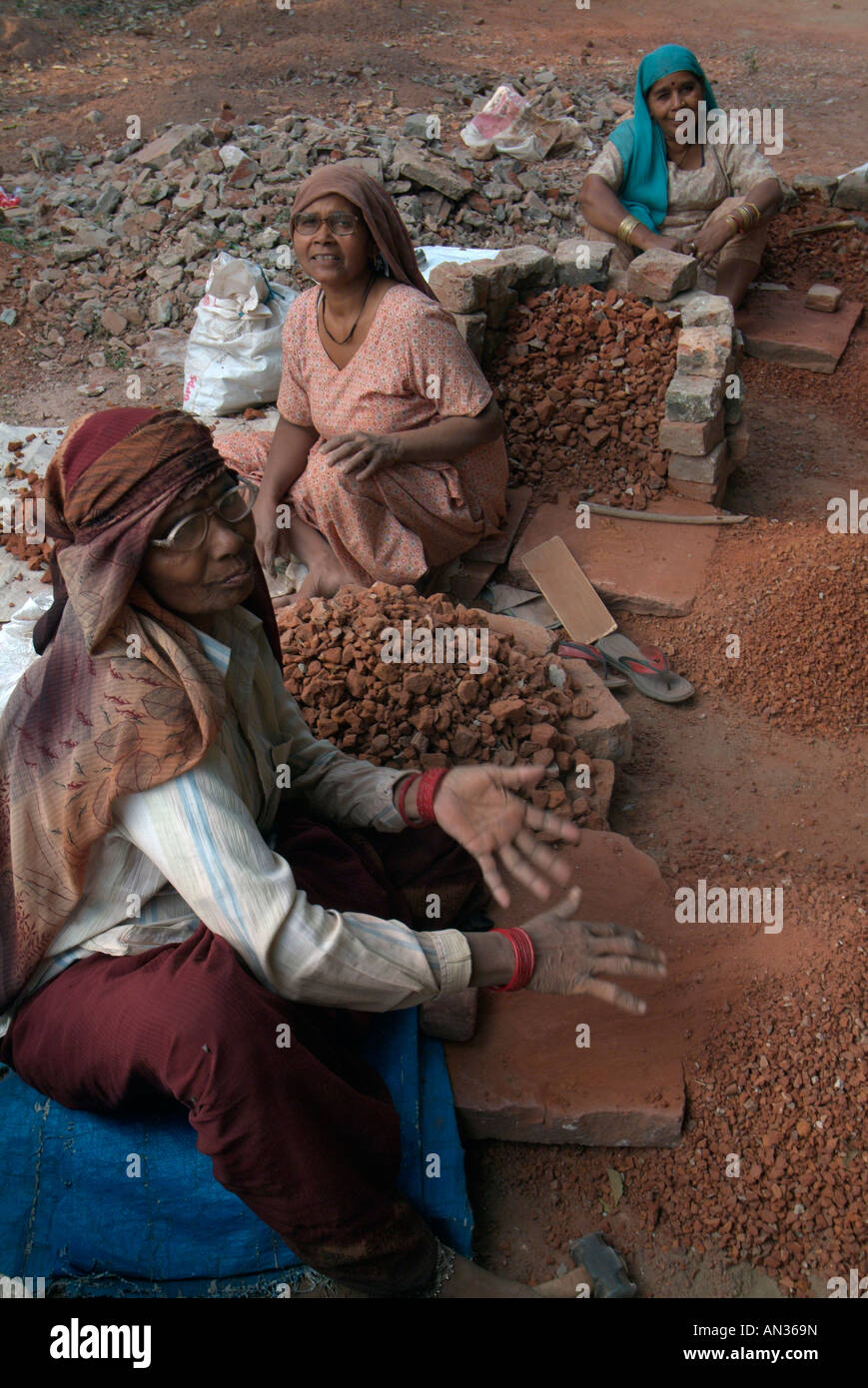 Female indian construction workers breaking stones by hand near a ...