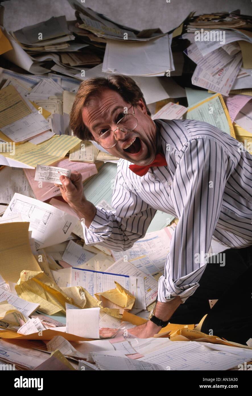 Businessman finds document in a mess of paperwork Stock Photo - Alamy