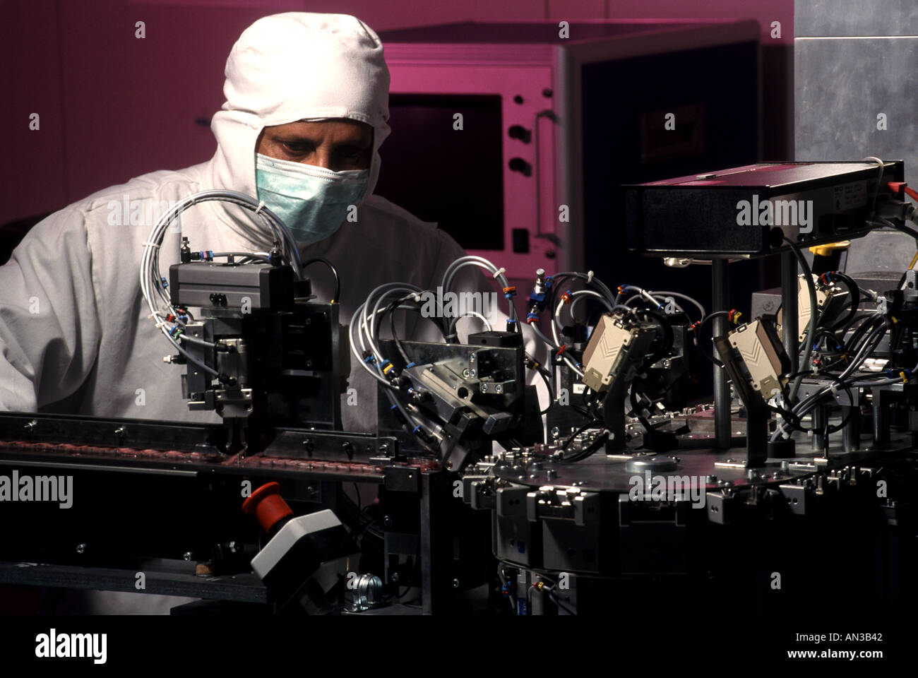 Quality control technician observes production of plastic medical ...